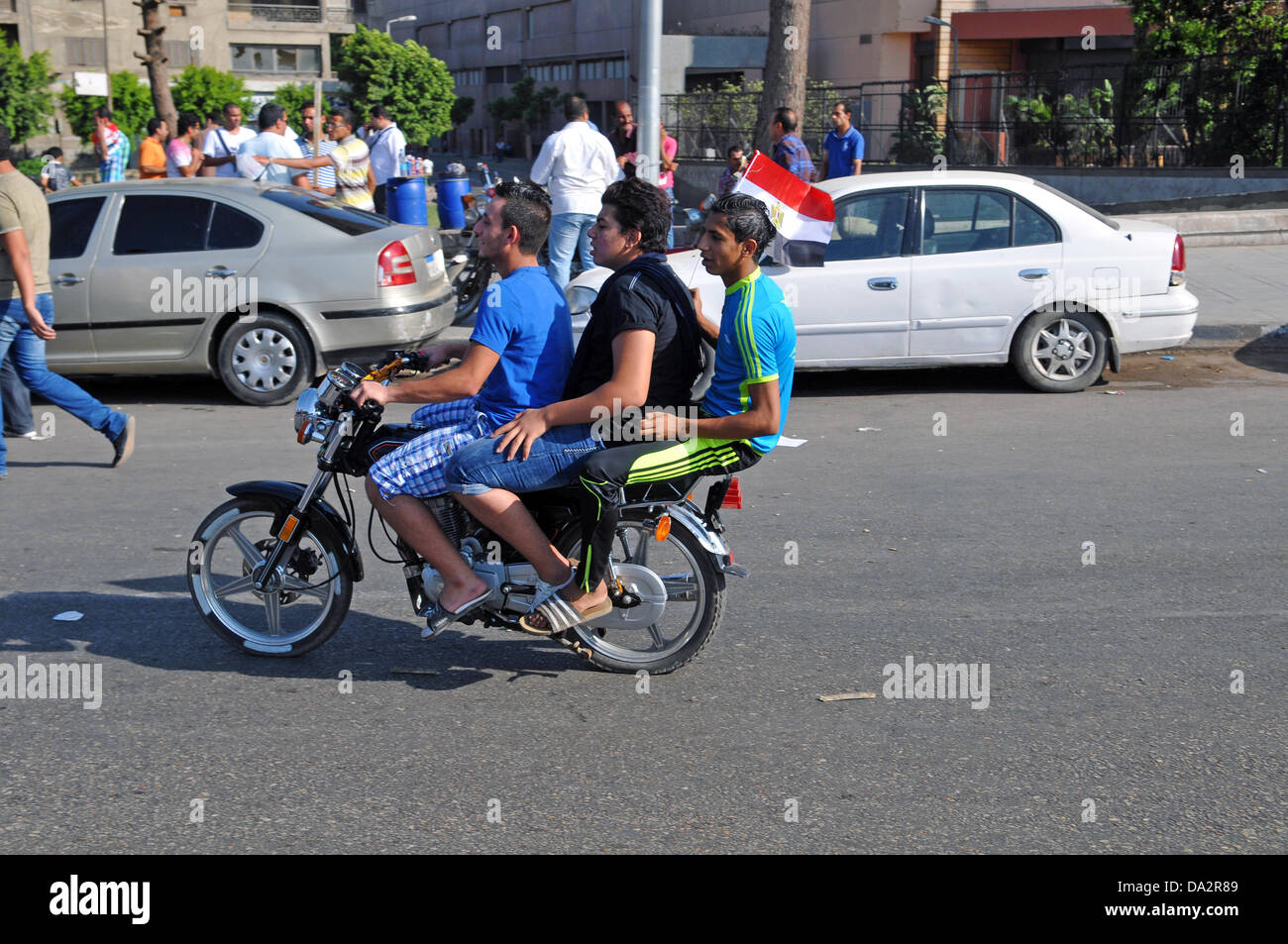 Three young men ride a motorcycle to a demonstration against Egyptian ...