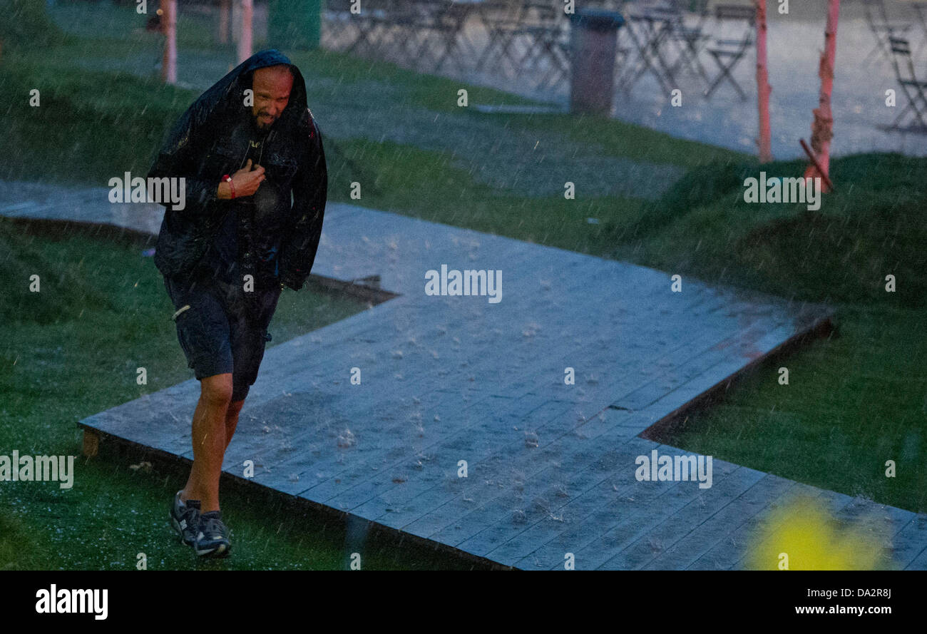 A man has pulled the coat over his head while trying to escape the rain ...