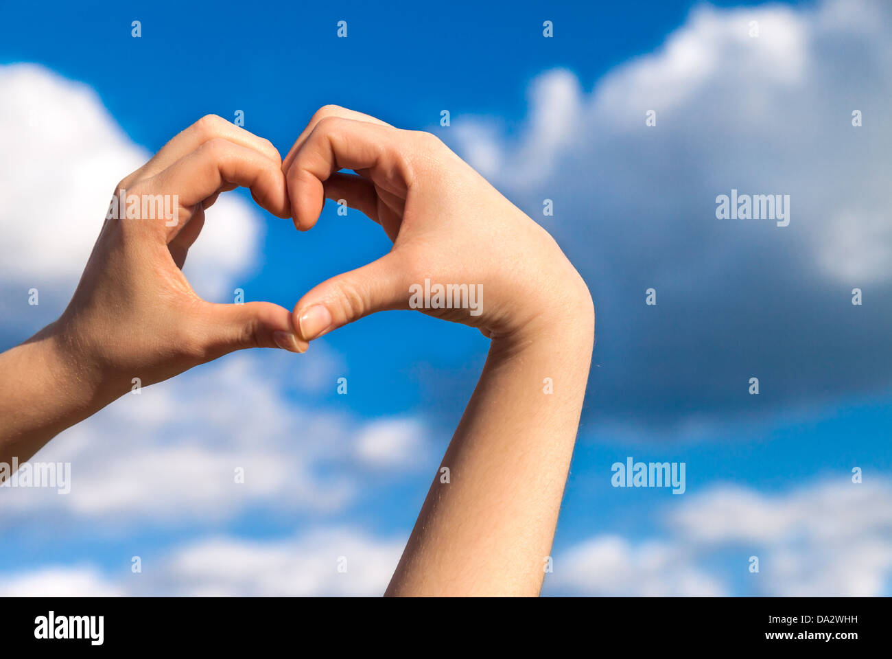 Woman Hands Forming A Heart Over The Blue Sky Stock Photo - Alamy
