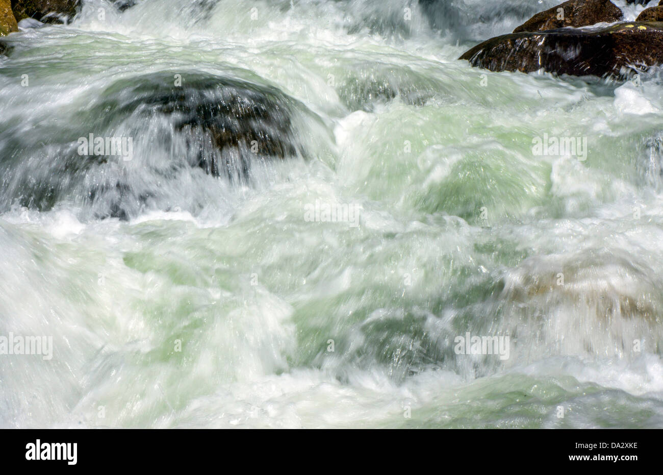 Stream with white water rushing over boulder Stock Photo - Alamy