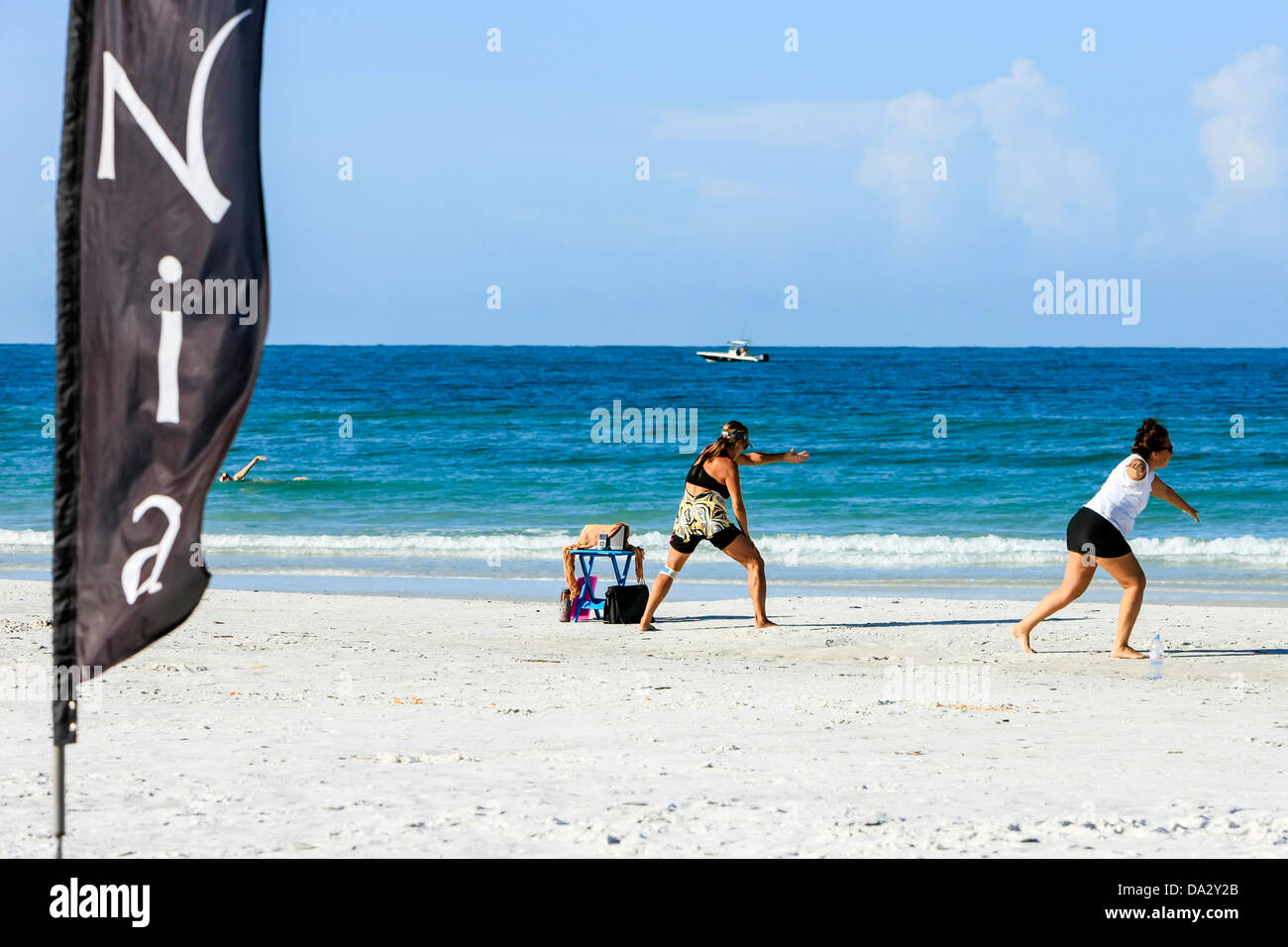 Women exercising the mind and body on the beach using the Nia technique ...