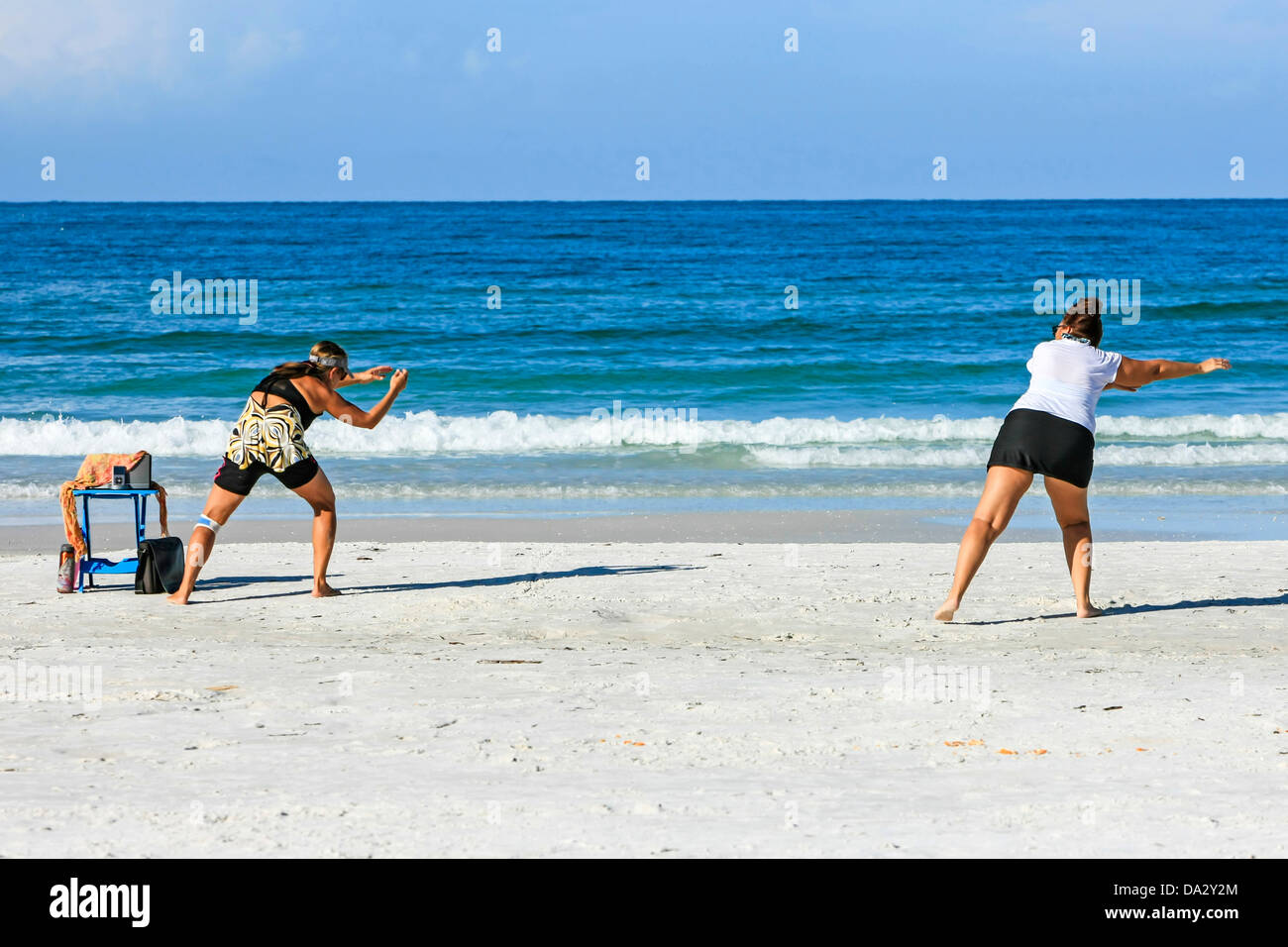 Women exercising the mind and body on the beach using the Nia technique ...