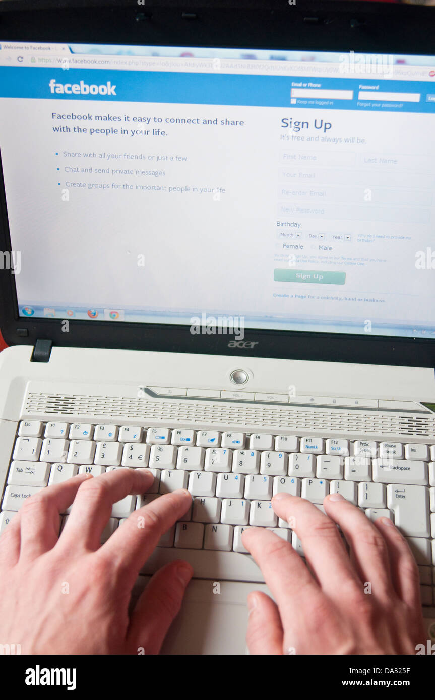 A man about to log in on facebook, social media site on his laptop ...