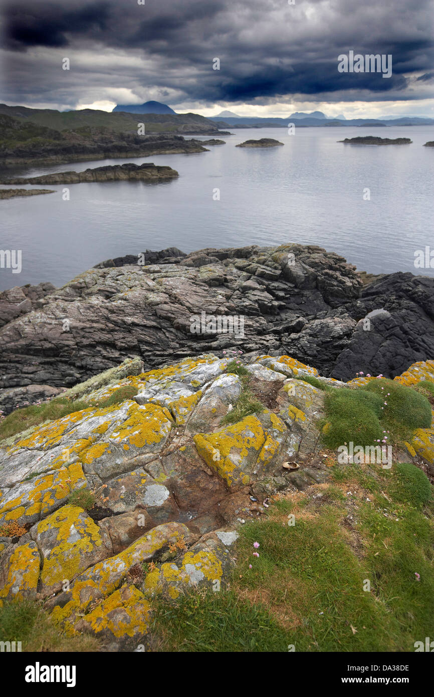 The rocky shoreline of Scourie Point, under a dramatic sky, looking ...
