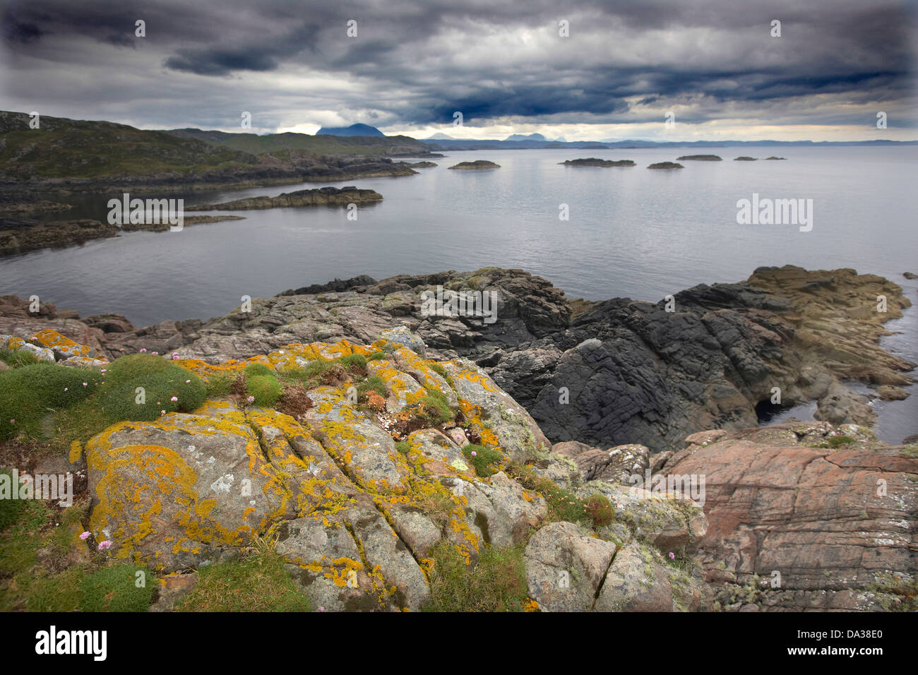 The rocky shoreline of Scourie Point, under a dramatic sky, looking ...