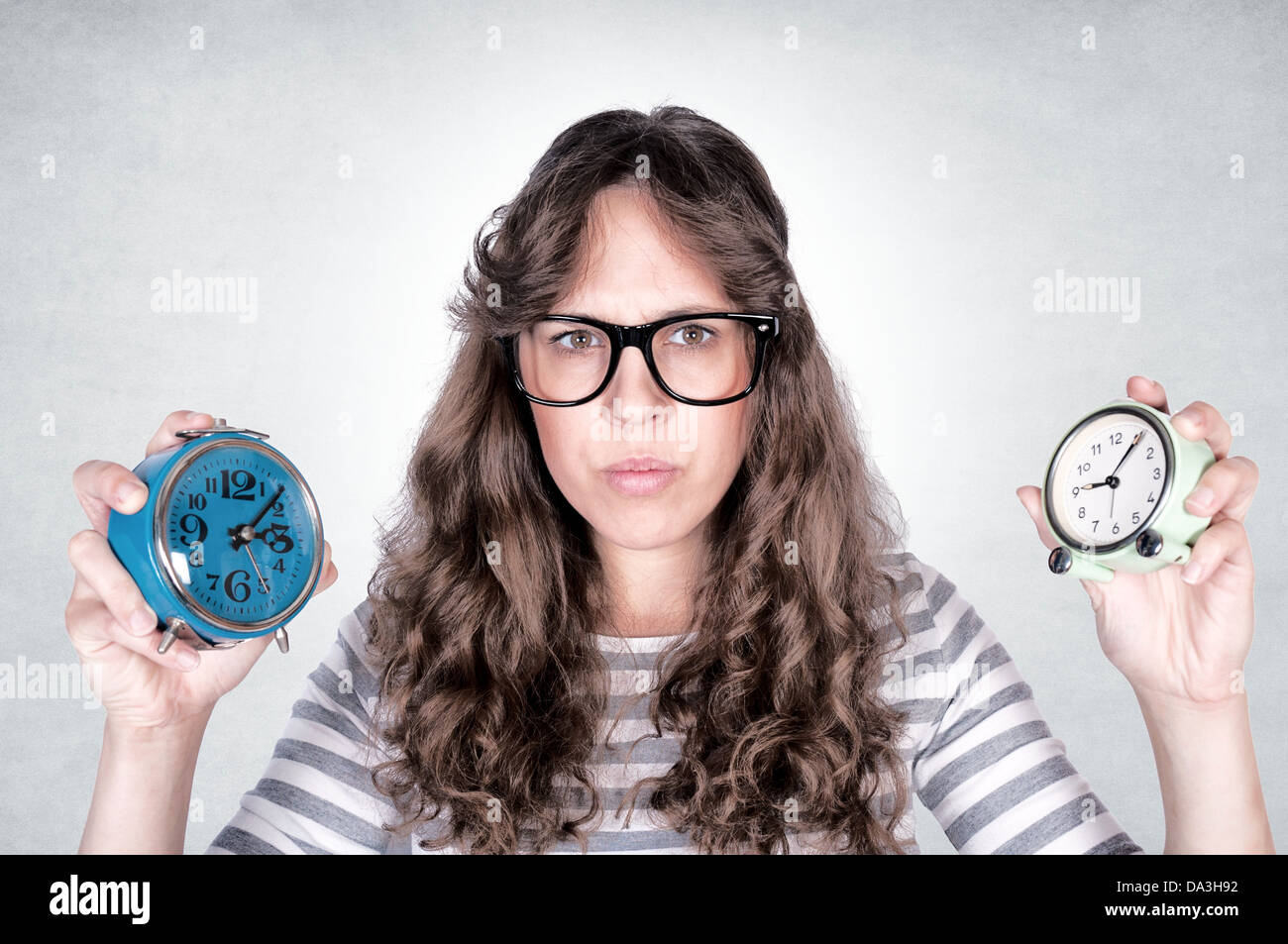 Female holding two clocks in her hands Stock Photo - Alamy