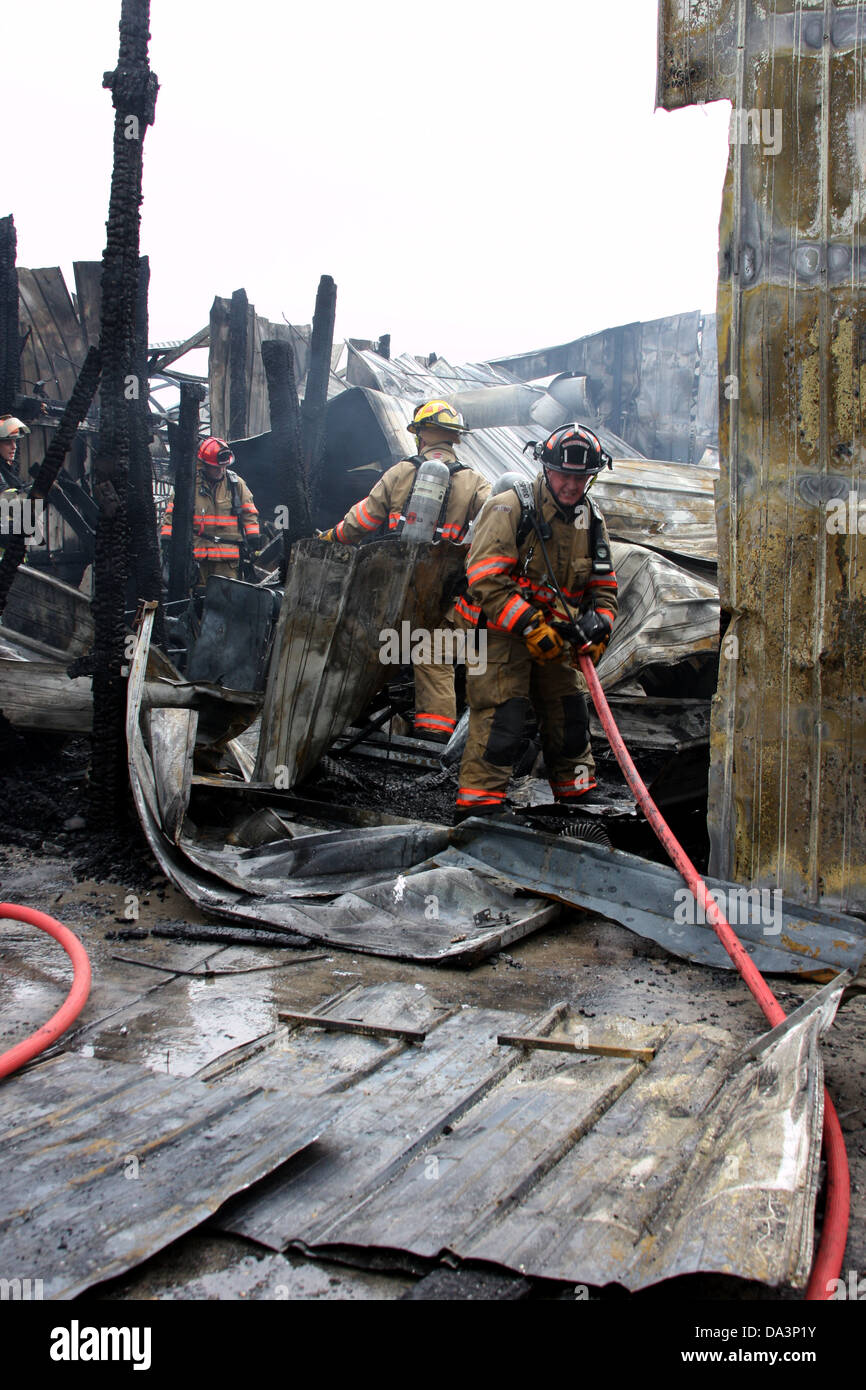 A firefighter pulling a hoseline into a collapsed building site Stock ...