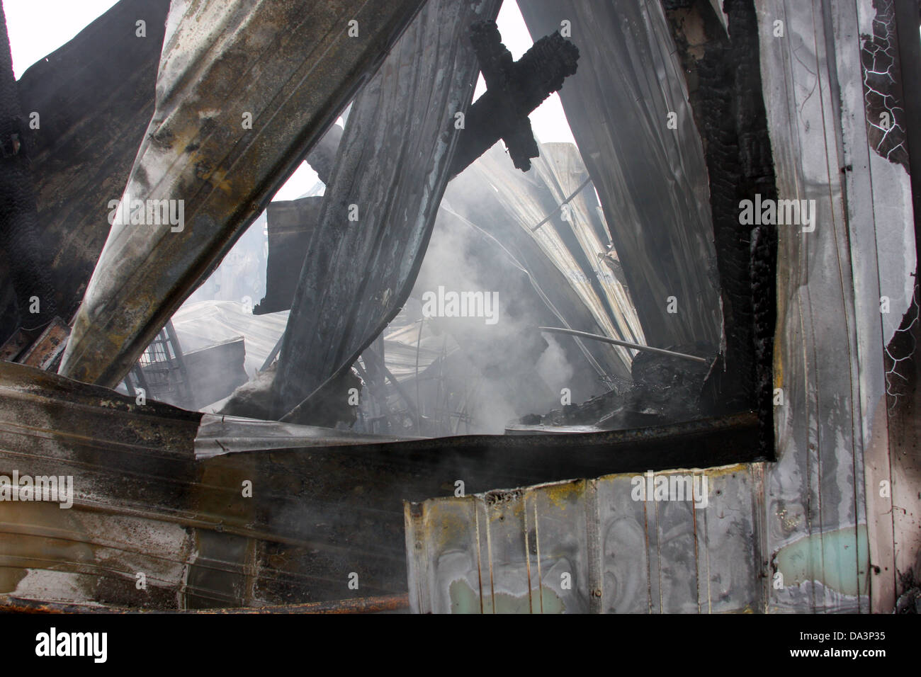 Smoke coming from a collapsed building still burning Stock Photo - Alamy