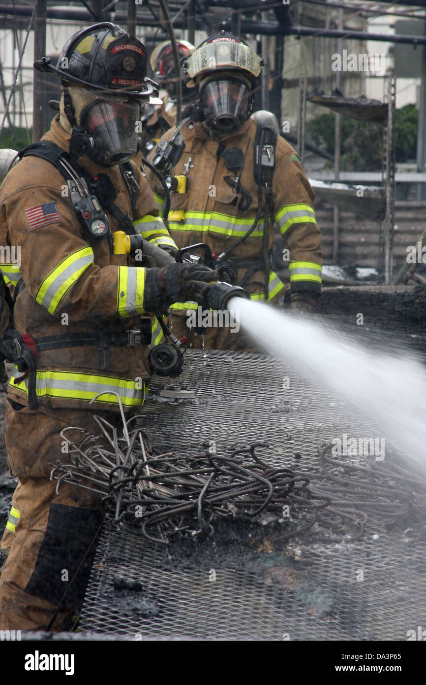 Firefighters working a scene to douse a fire in a greenhouse Stock ...