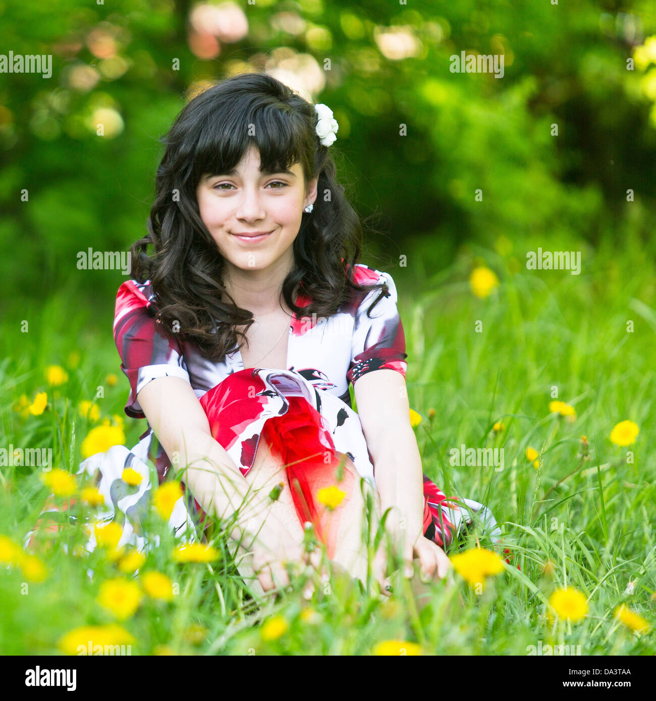 A young pretty girl sitting in the grass Stock Photo - Alamy