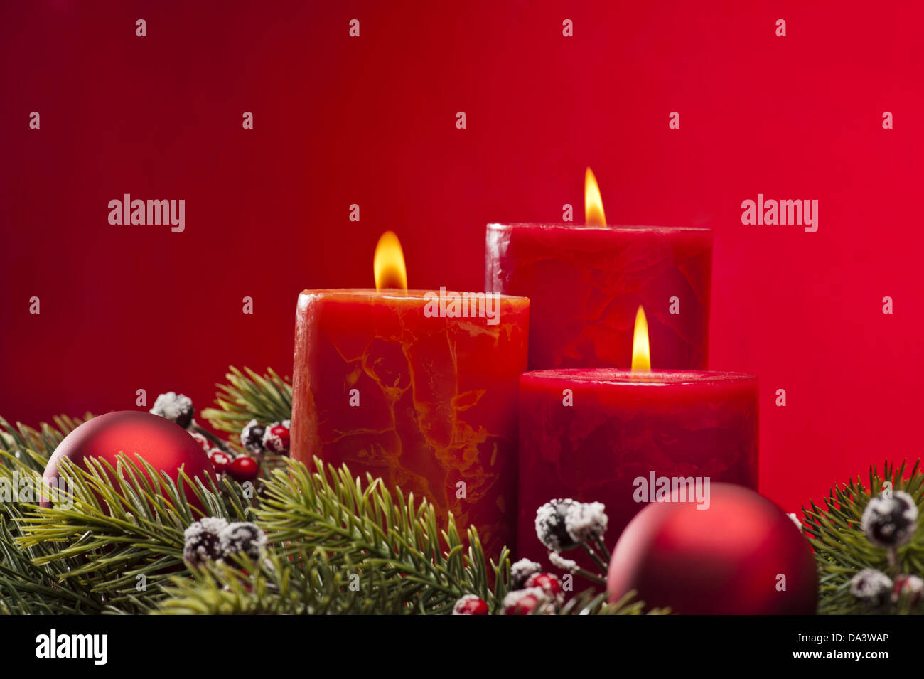 Red advent flower arrangement with burning candles Stock Photo - Alamy