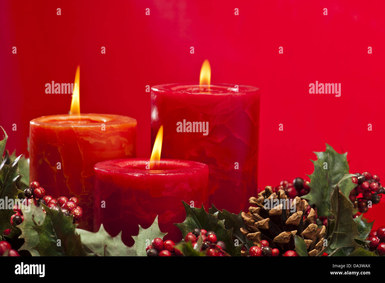 Red advent flower arrangement with burning candles Stock Photo - Alamy