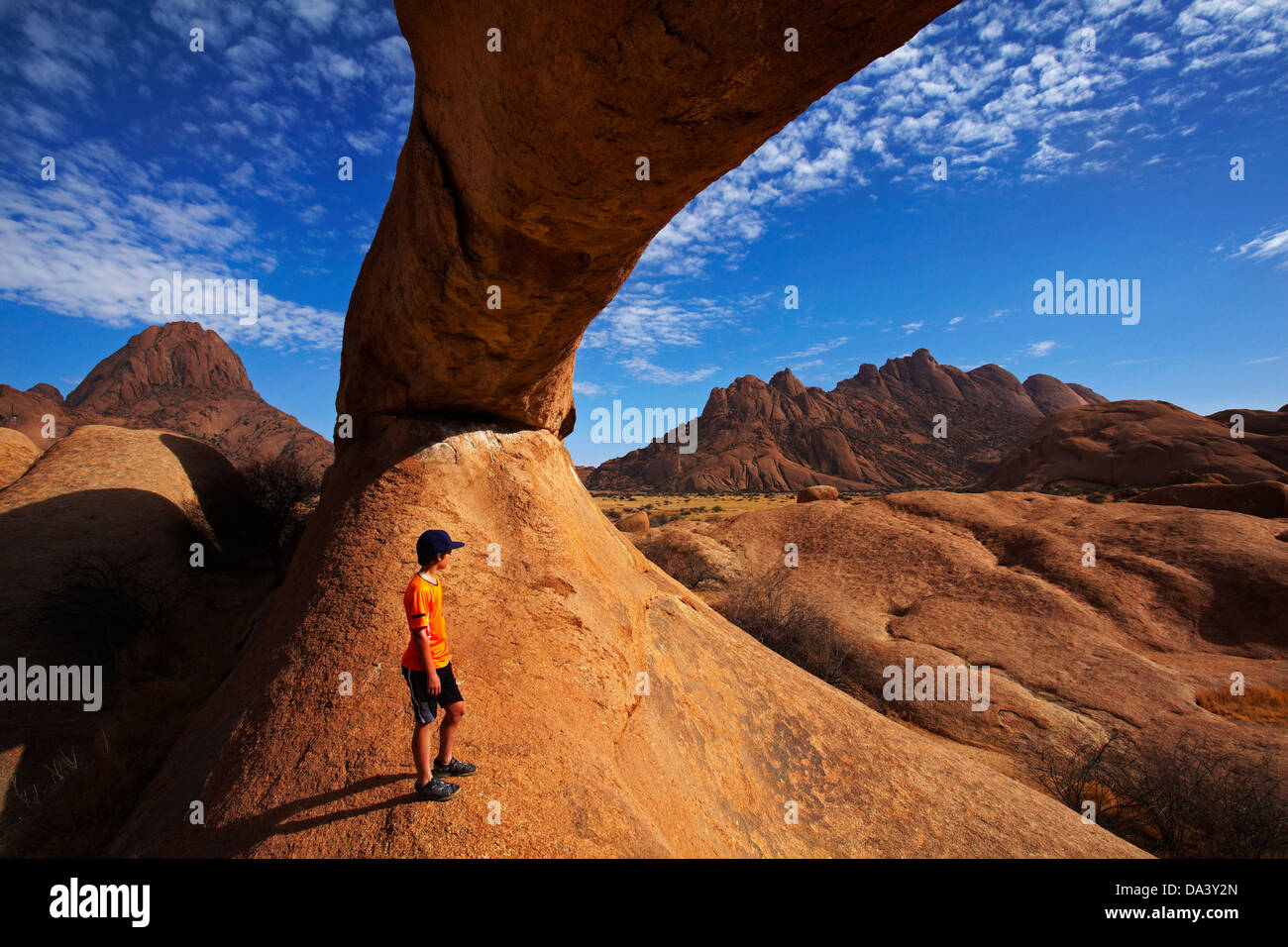 Boy under natural rock arch at Spitzkoppe (left), and Pondok Mountains ...