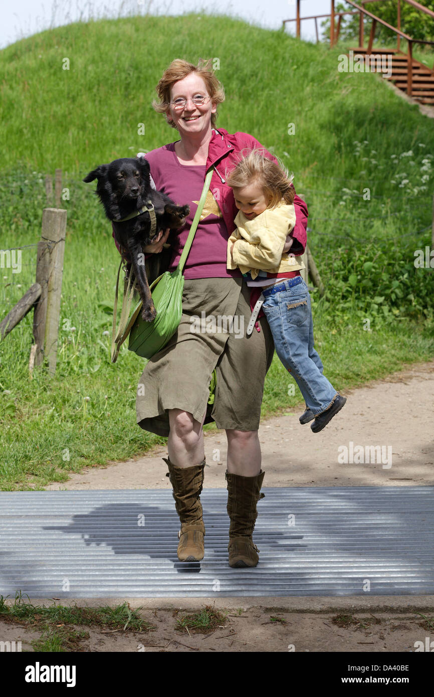 a woman carrying dog and child, Haithabu, Schleswig-Holstein, Germany ...