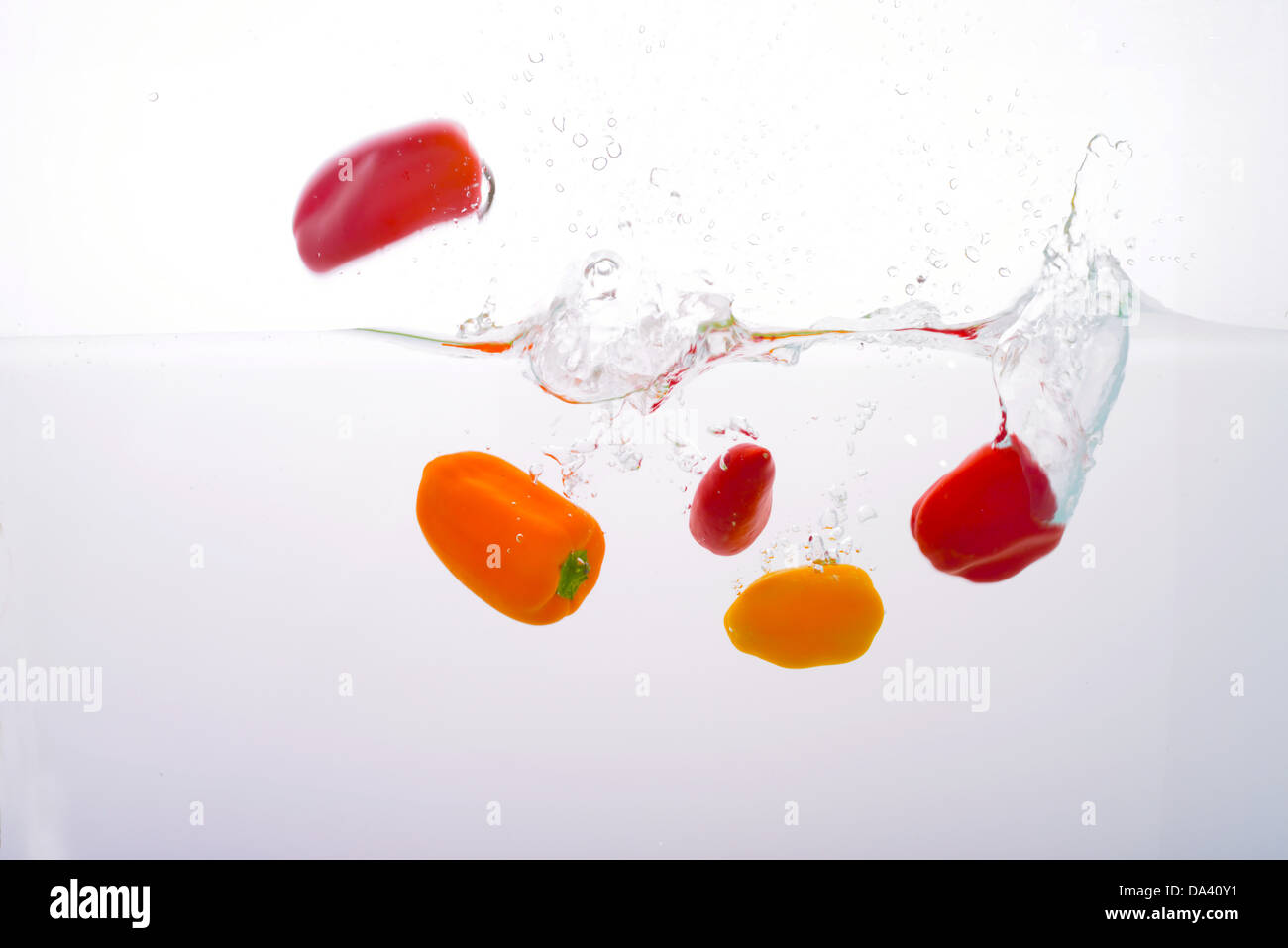 Small peppers splashed into water Stock Photo - Alamy