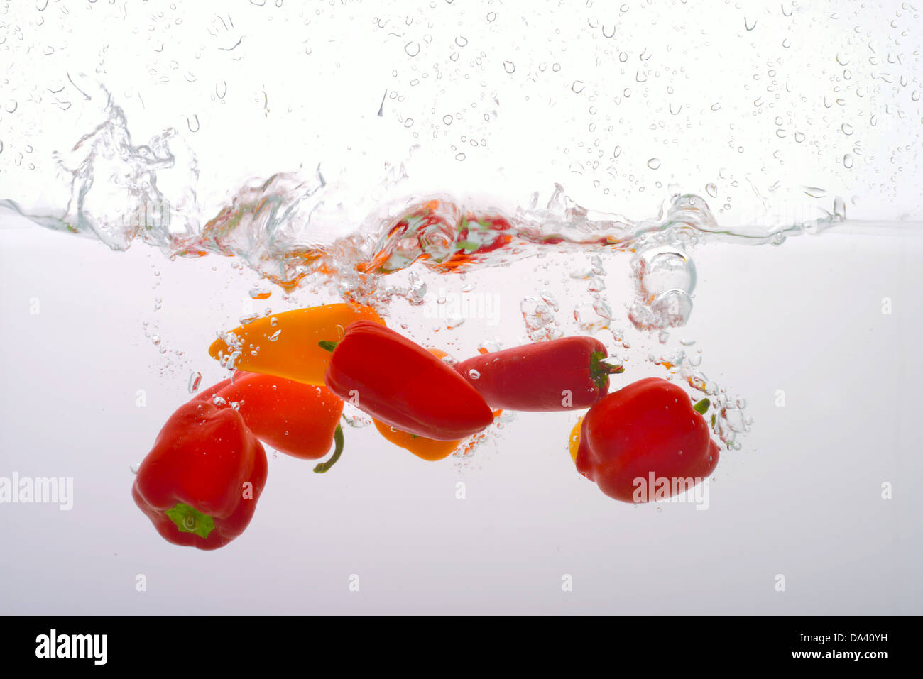 Small peppers splashed into water Stock Photo - Alamy