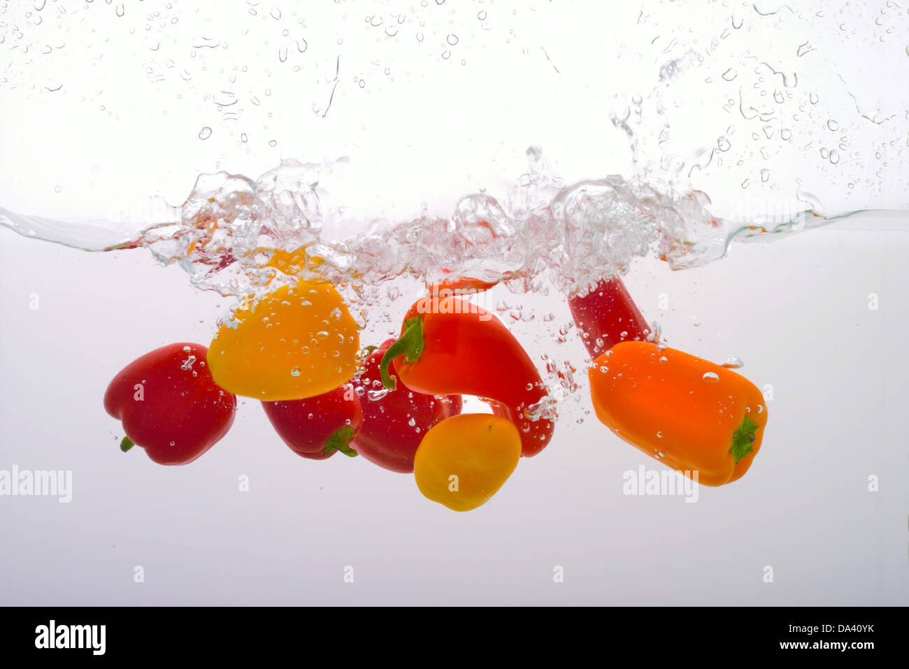 Small peppers splashed into water Stock Photo - Alamy