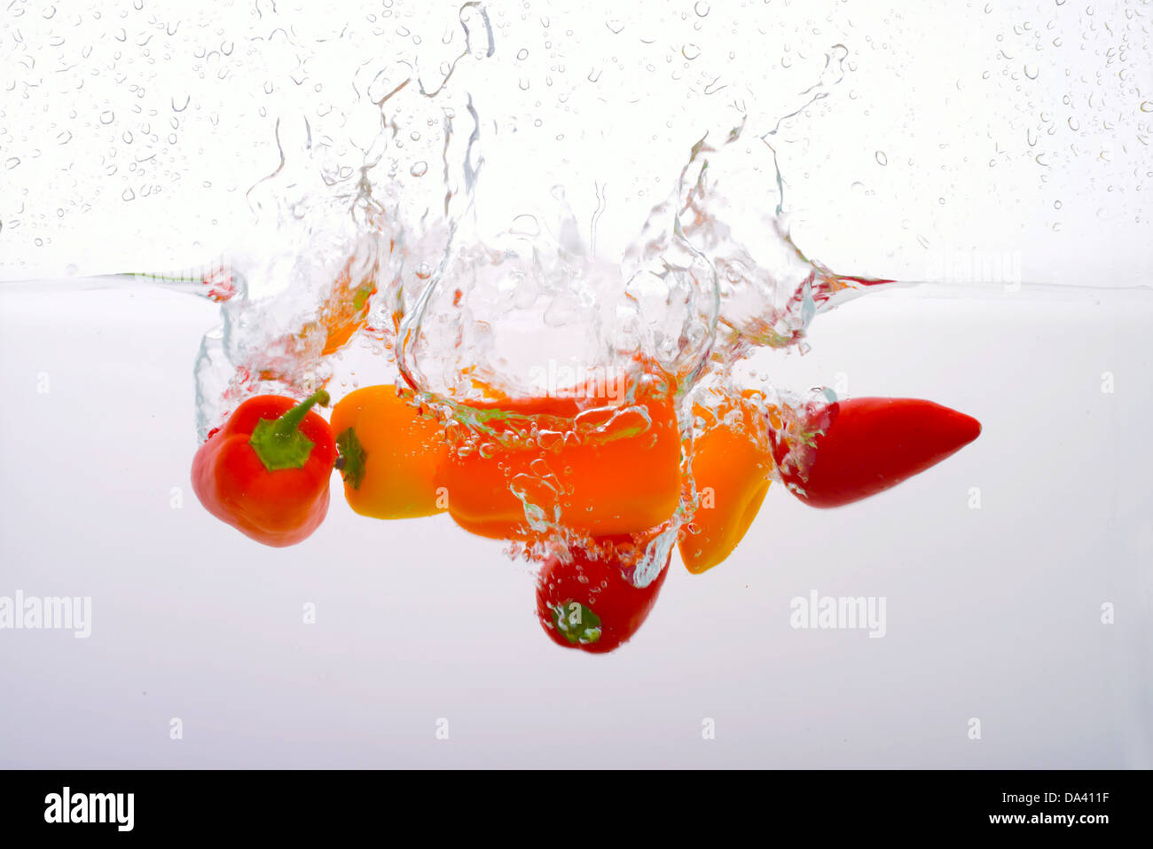 Small peppers splashed into water Stock Photo - Alamy