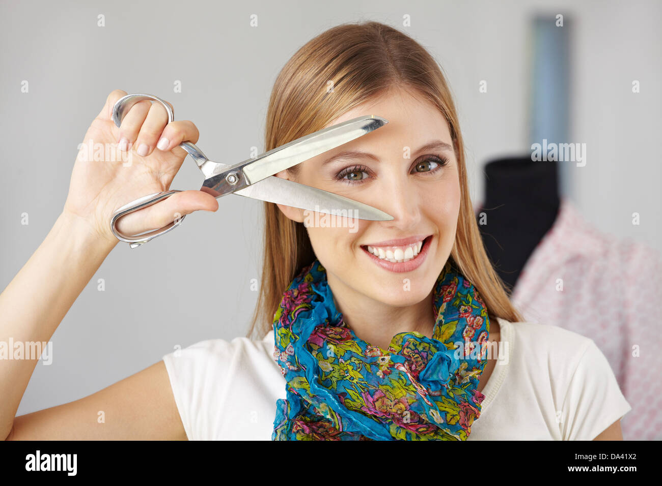 Smiling attractive woman with scissors in front of her face Stock Photo ...