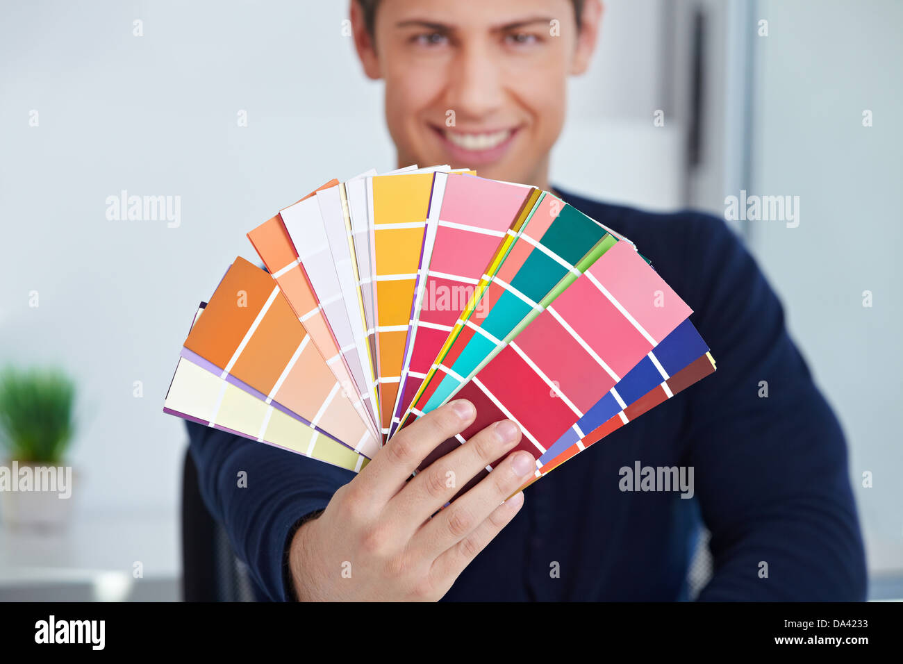 Happy graphic designer holding color fan in his hand Stock Photo - Alamy