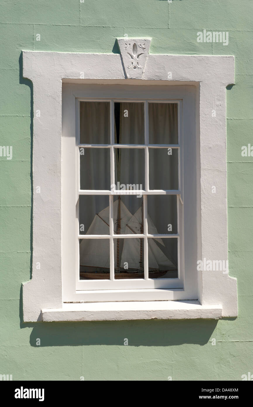 Model ship in olourful painted green and white house window surround ...