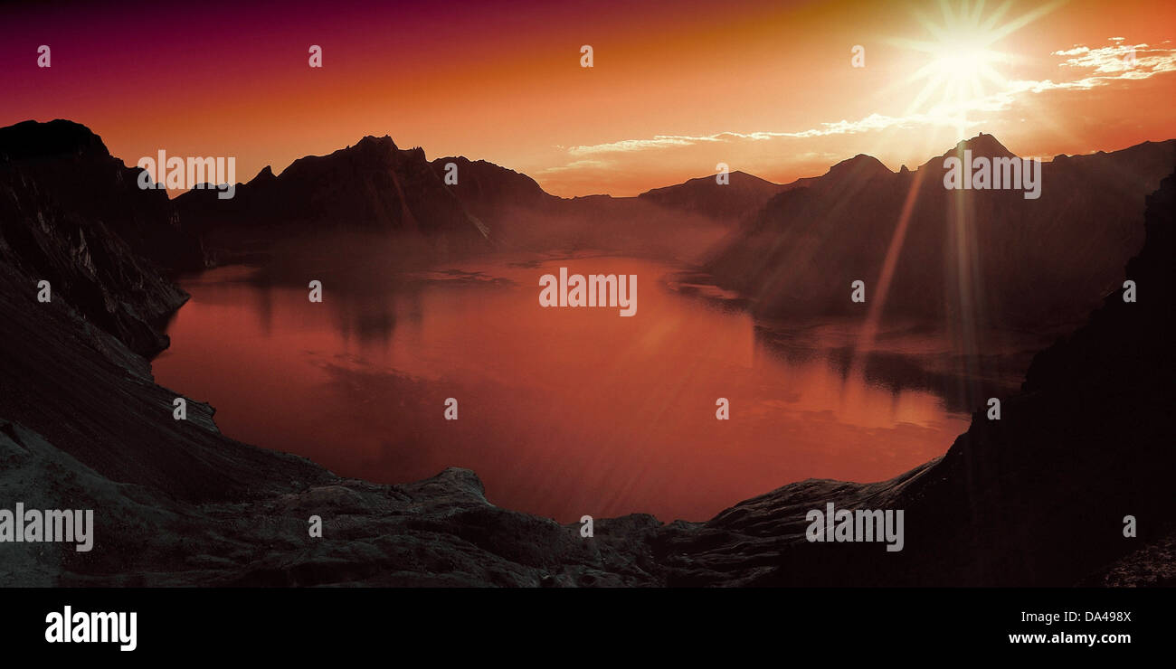 A stunning sunset over a lake with mountains in the background ...