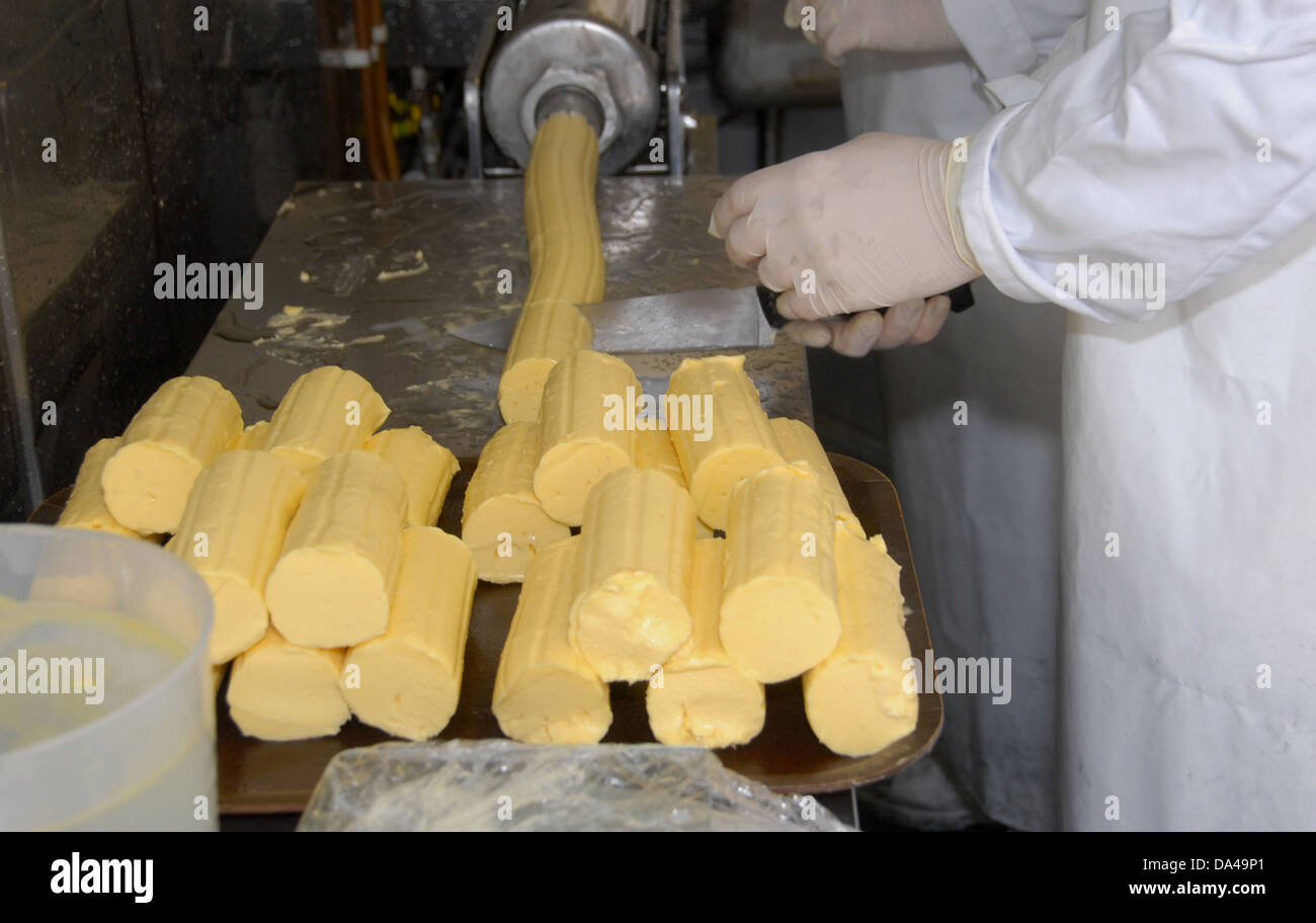 Worker cutting up butter patts making organically made butter from ...