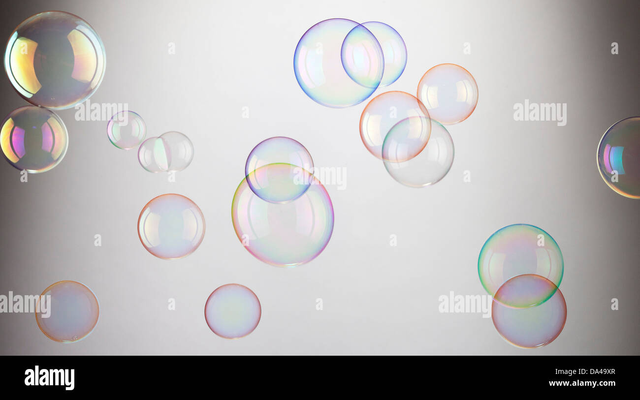 colourful bubbles of different sizes floating before a gray background ...