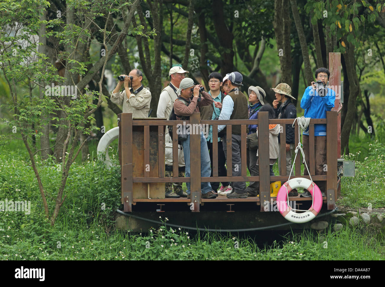 Birdwatchers with binoculars and camera on platform contestants in ...