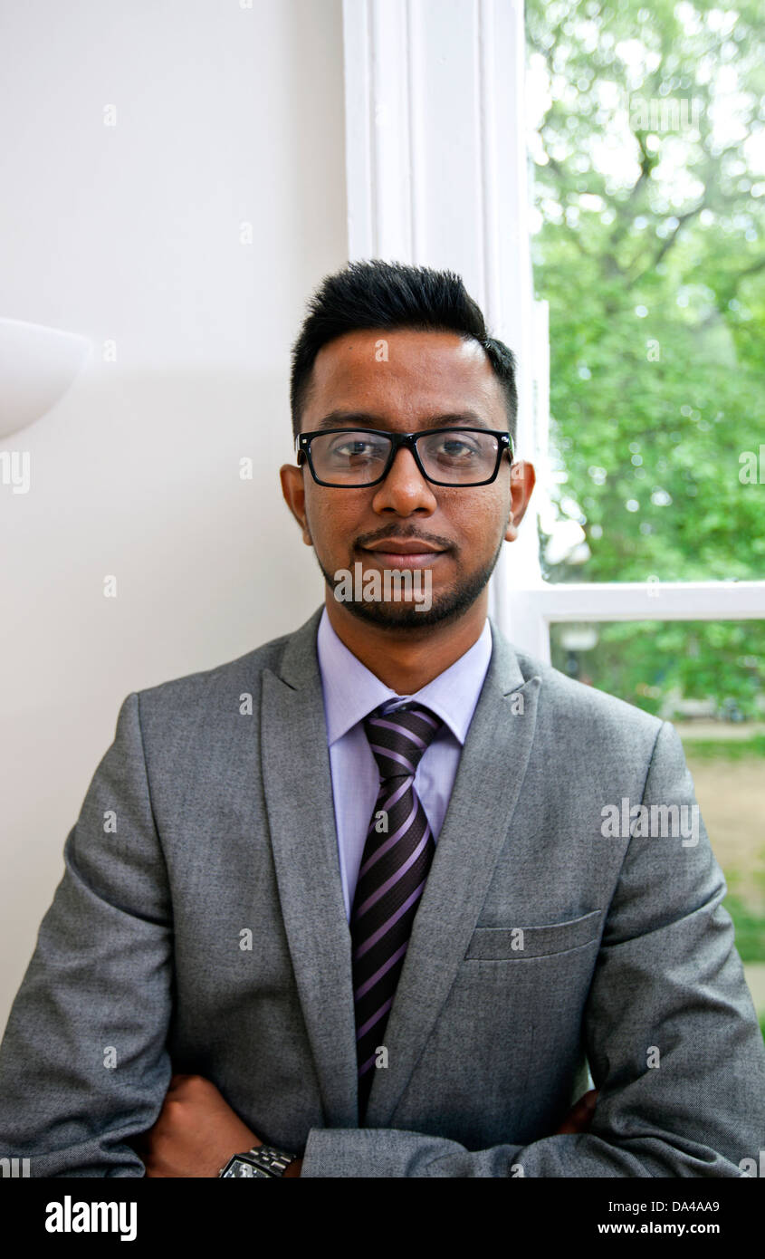 Portrait Of Indian Businessman Wearing Glasses With Hands Folded Stock