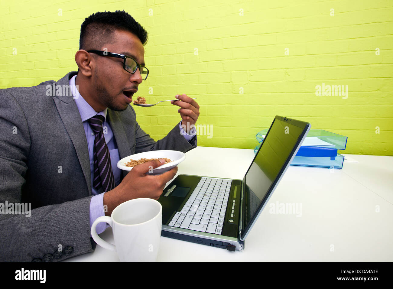 Close up of woman eating at her desk Stock Photo - Alamy