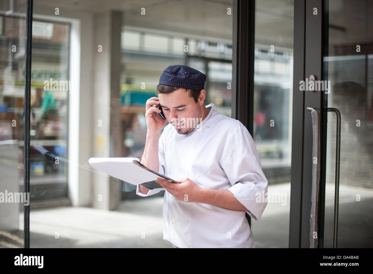 Soho chef reading order list outside restaurant Stock Photo - Alamy