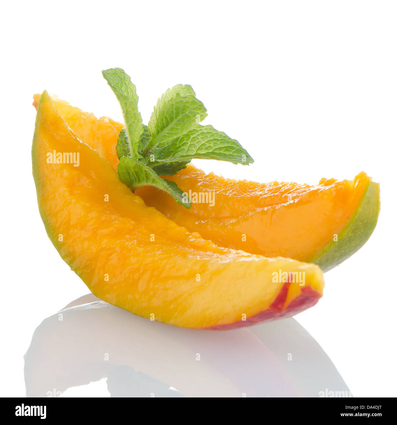 Mango fruit slices on white reflective background Stock Photo - Alamy