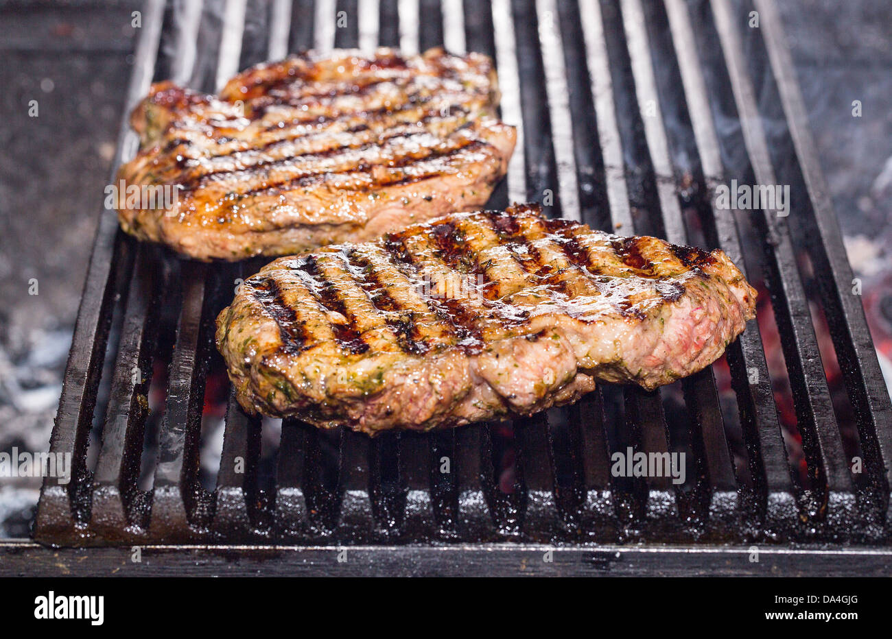 cooking beef steak on a grill in the restaurant Stock Photo - Alamy
