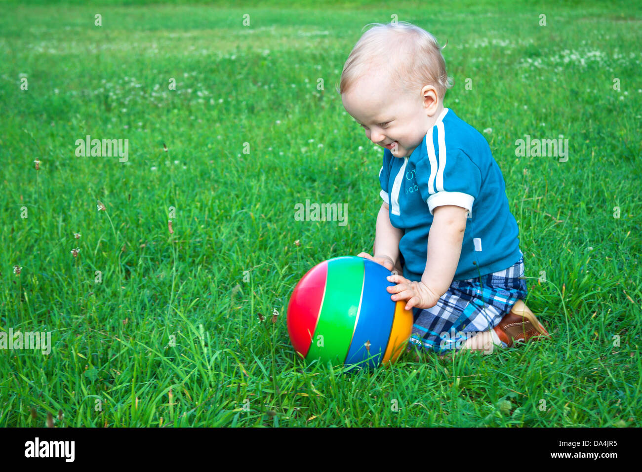 the small child plays on a green summer meadow Stock Photo - Alamy