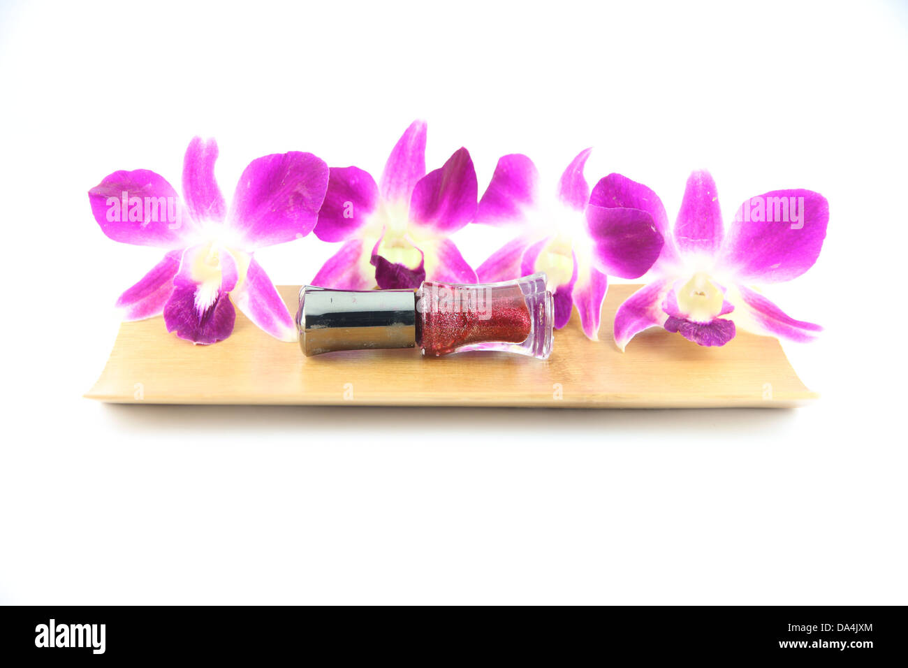 Purple orchid and perfume bottles in bamboo dish on white background ...