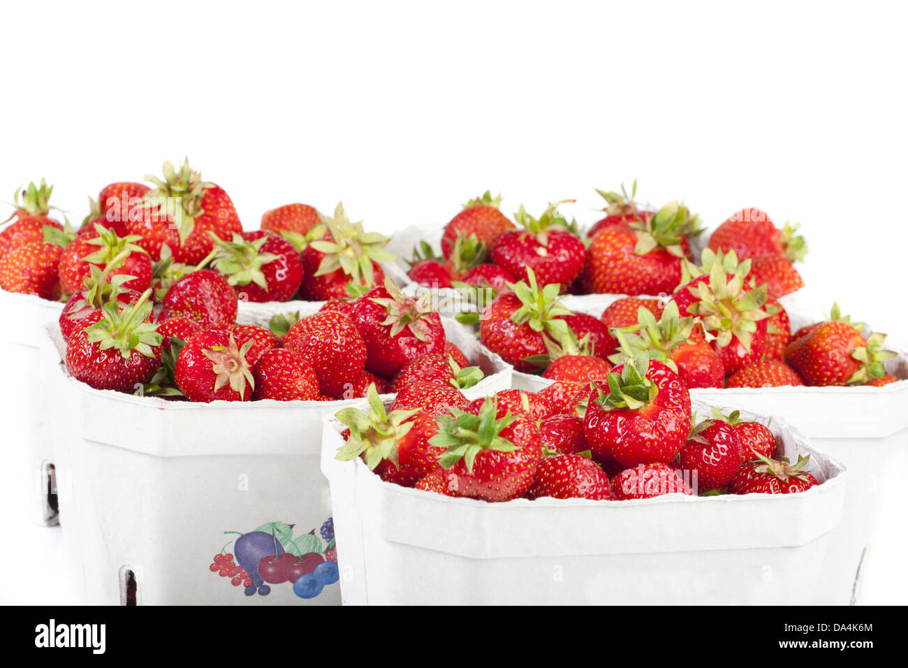 Many strawberries in cardboard boxes lined up on a white background ...