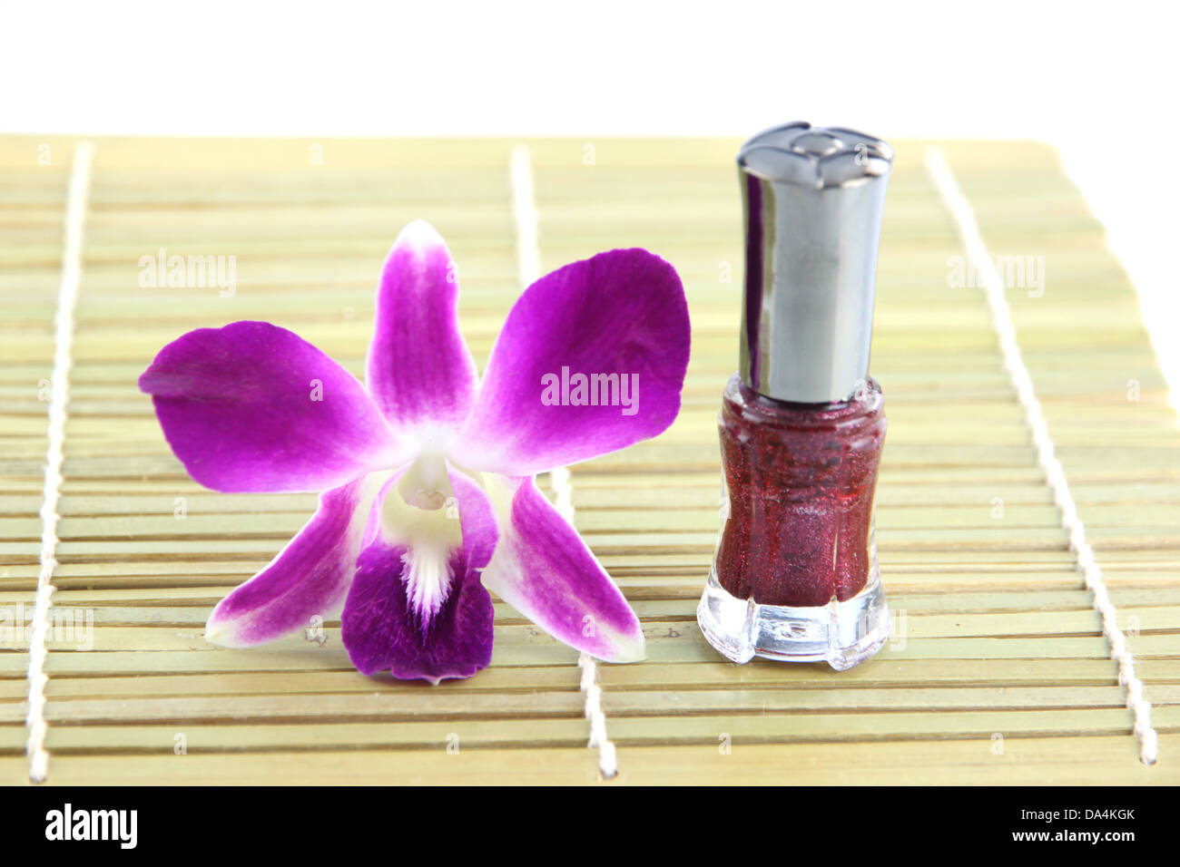 Purple orchid and perfume bottles in bamboo dish on white background ...