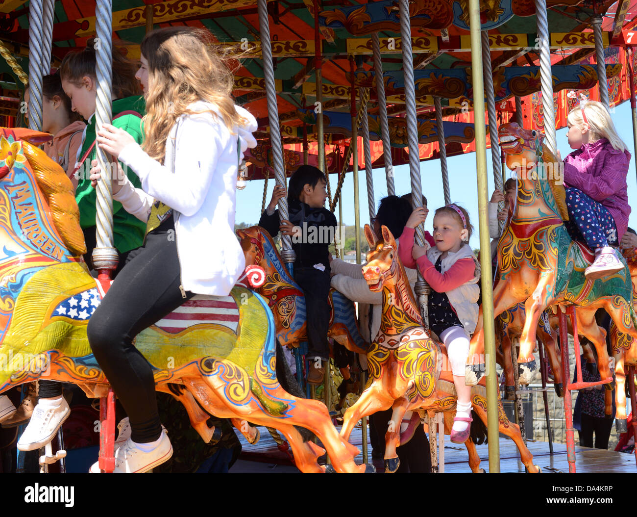 Children enjoying the merry go round at the fairground Stock Photo - Alamy
