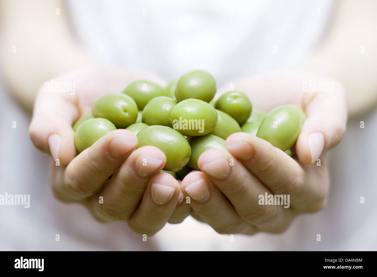 Human hands holding green olive Stock Photo - Alamy