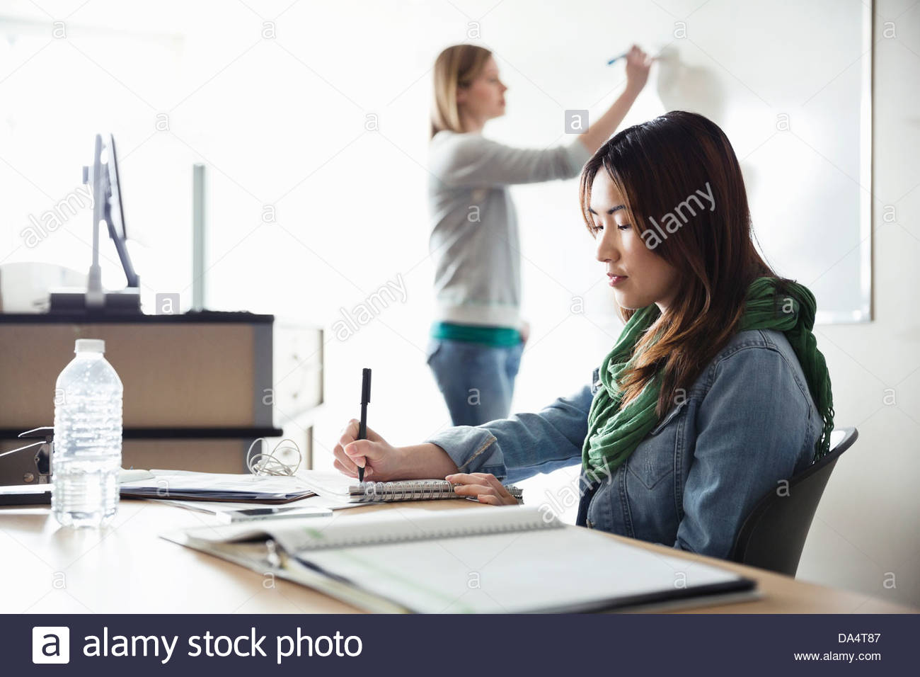 Female students working in classroom at college campus Stock Photo - Alamy