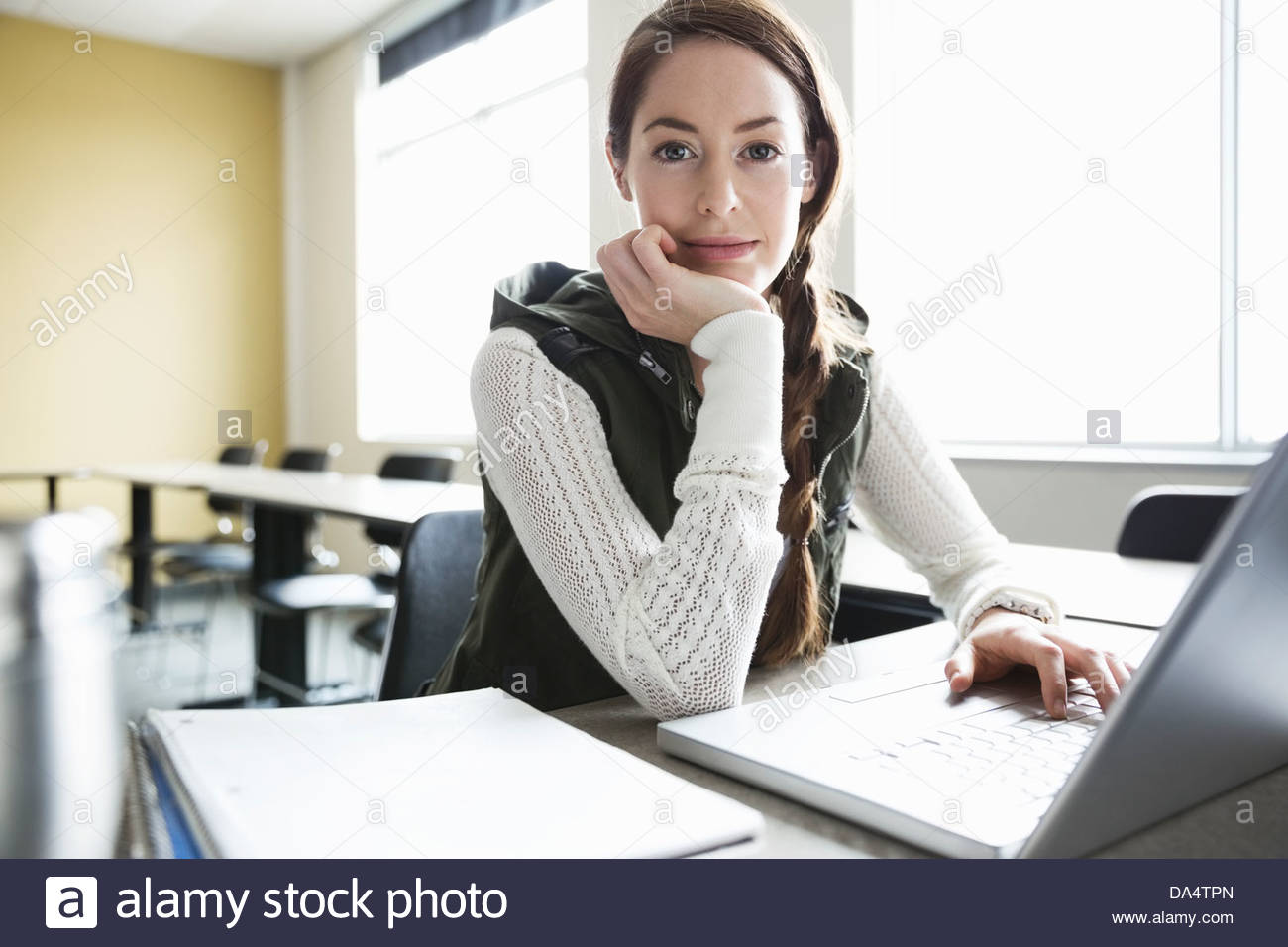 Portrait of female student working on laptop in college classroom Stock ...