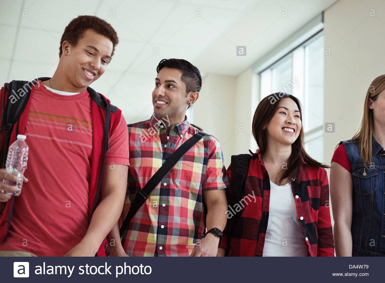 Group of students walking through college campus hallway Stock Photo - Alamy