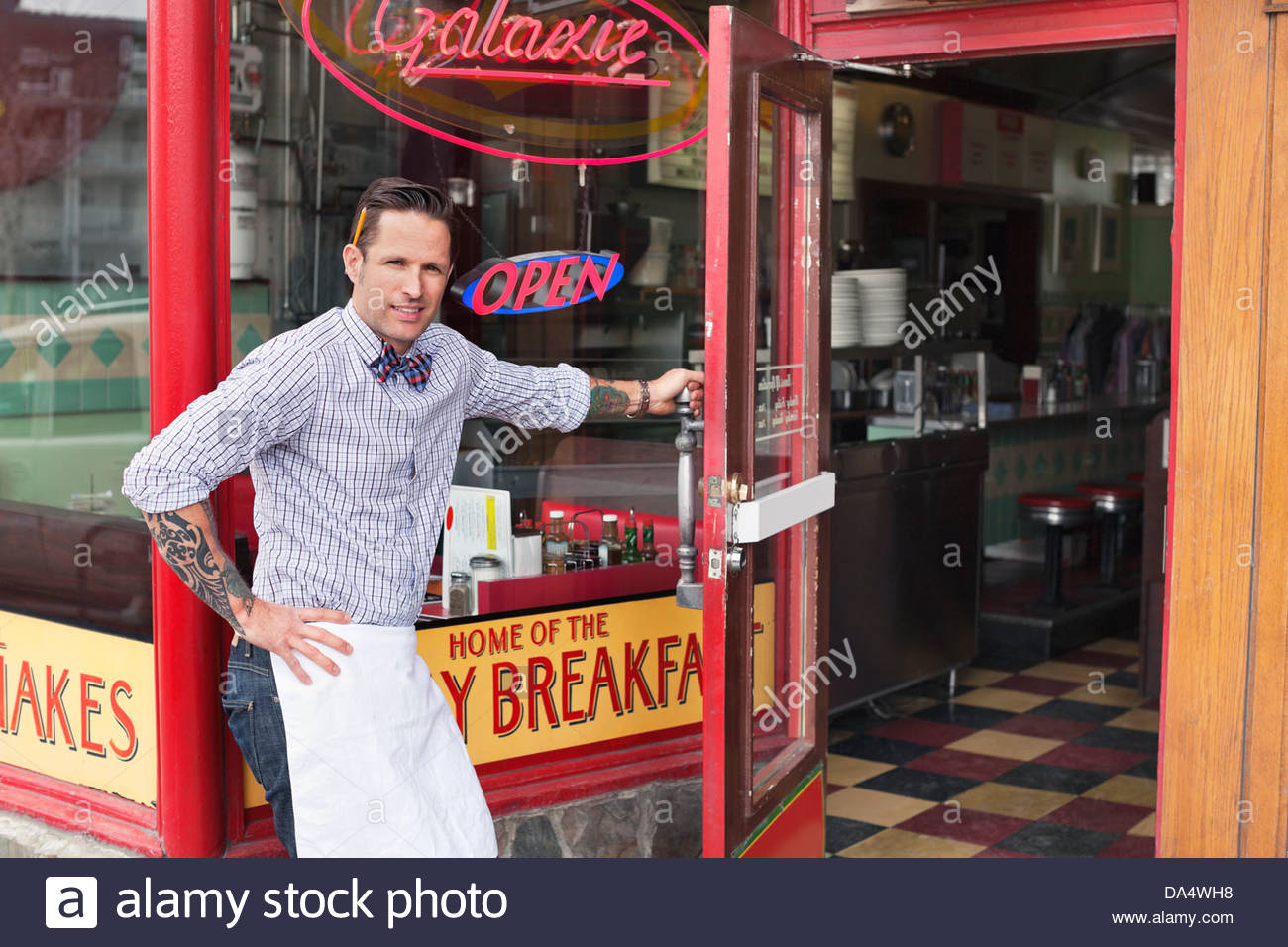 Portrait of male business owner opening diner door Stock Photo - Alamy