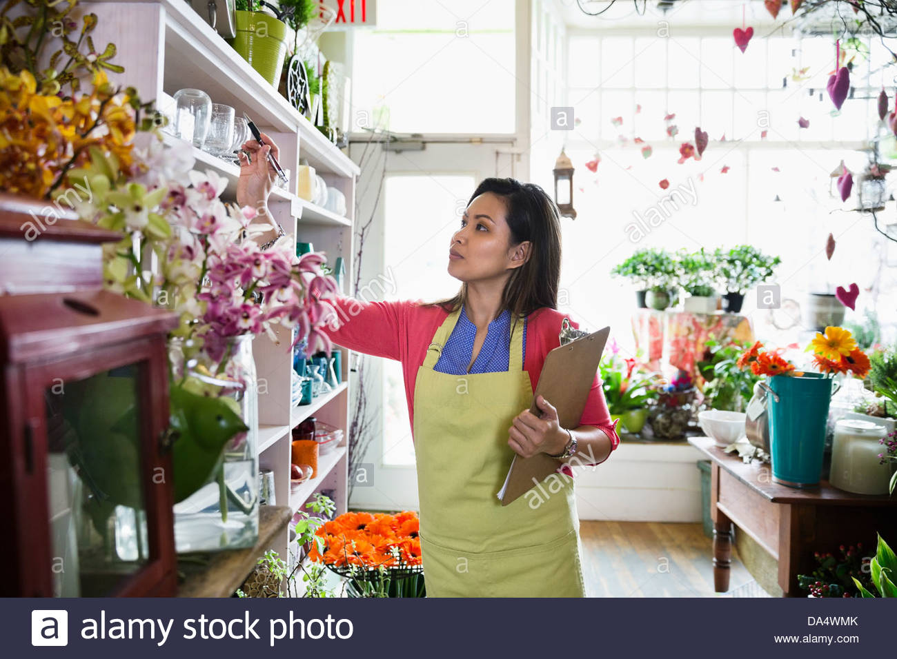 Female florist taking inventory in flower shop Stock Photo - Alamy