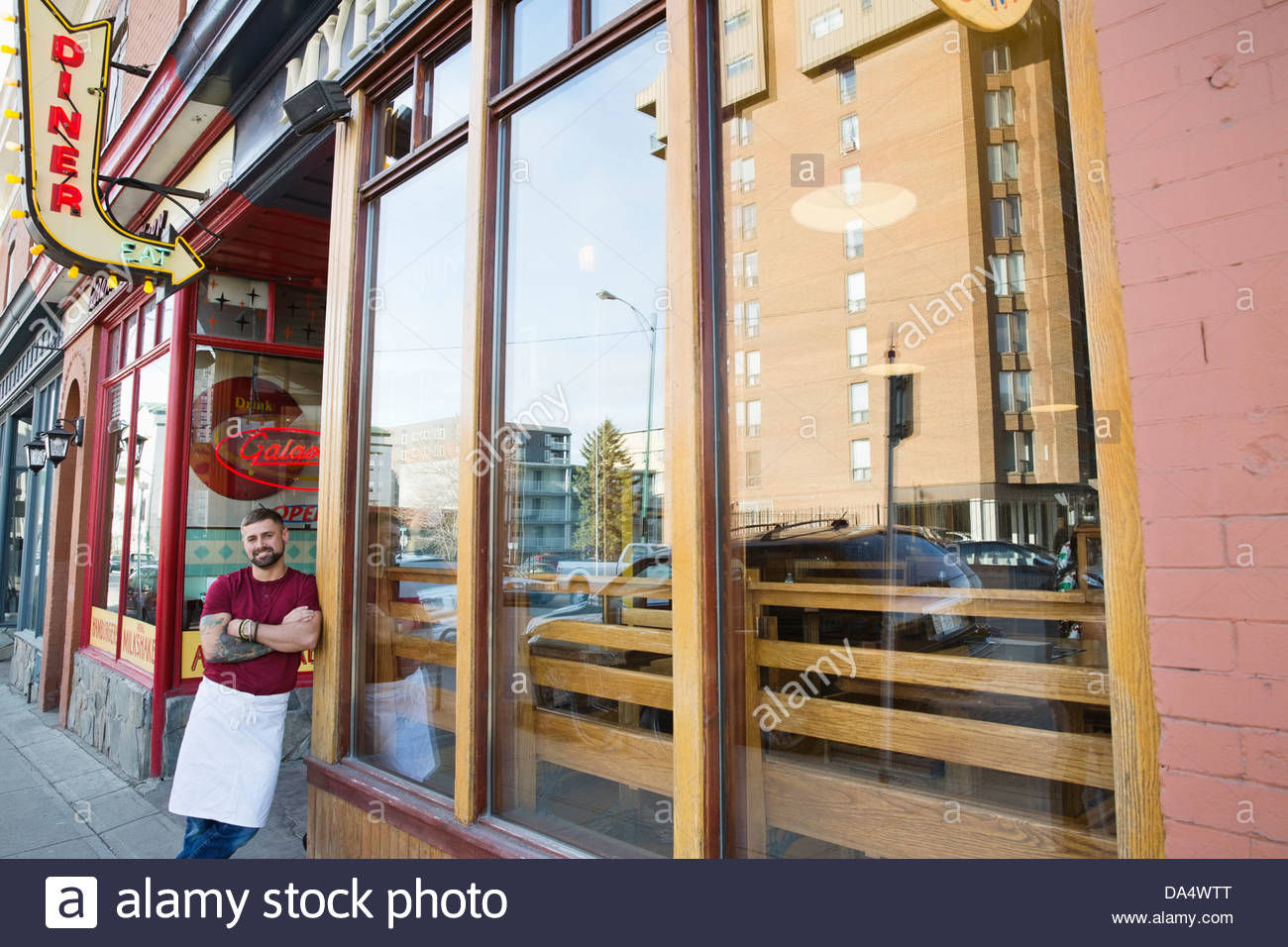 Portrait of male deli owner standing outside restaurant Stock Photo - Alamy