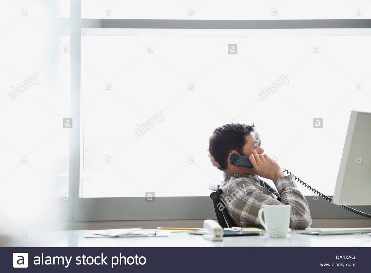 Businessman talking on telephone in office Stock Photo - Alamy