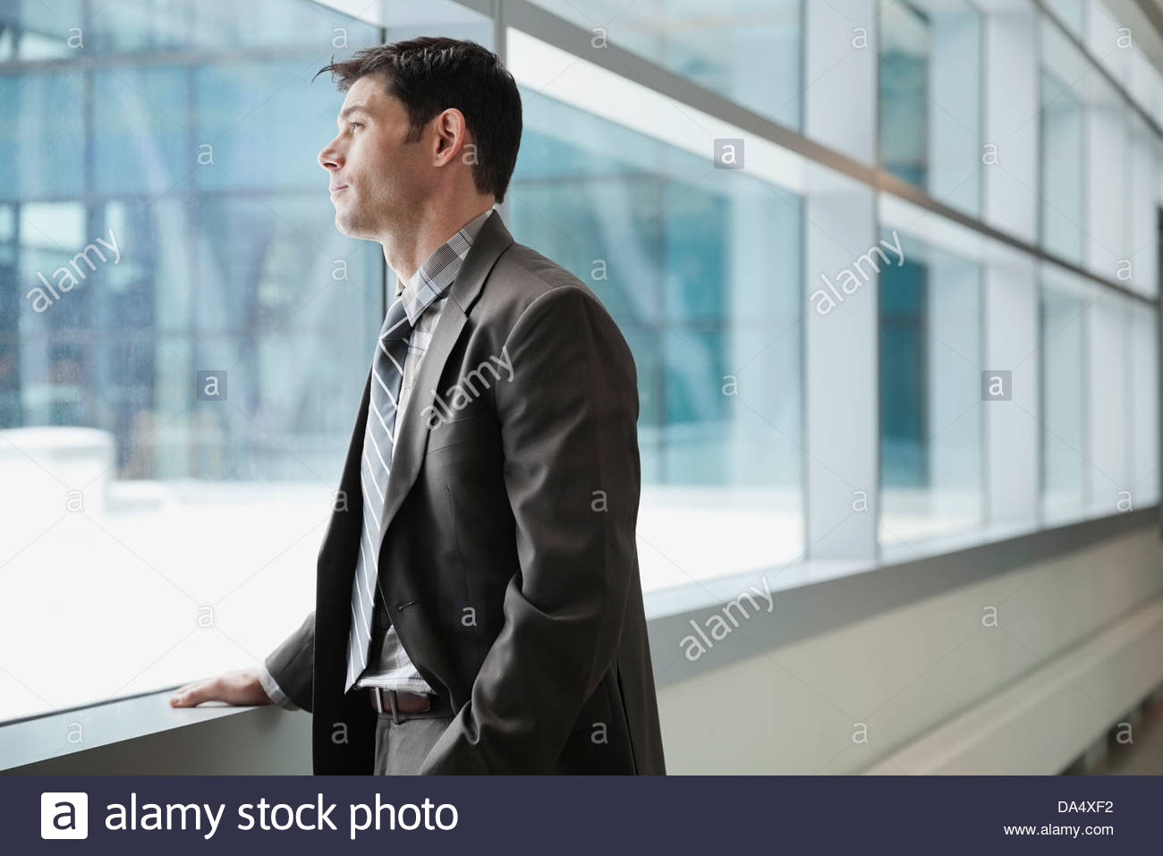 Full length side view of a businessman struggling to carry globe on ...