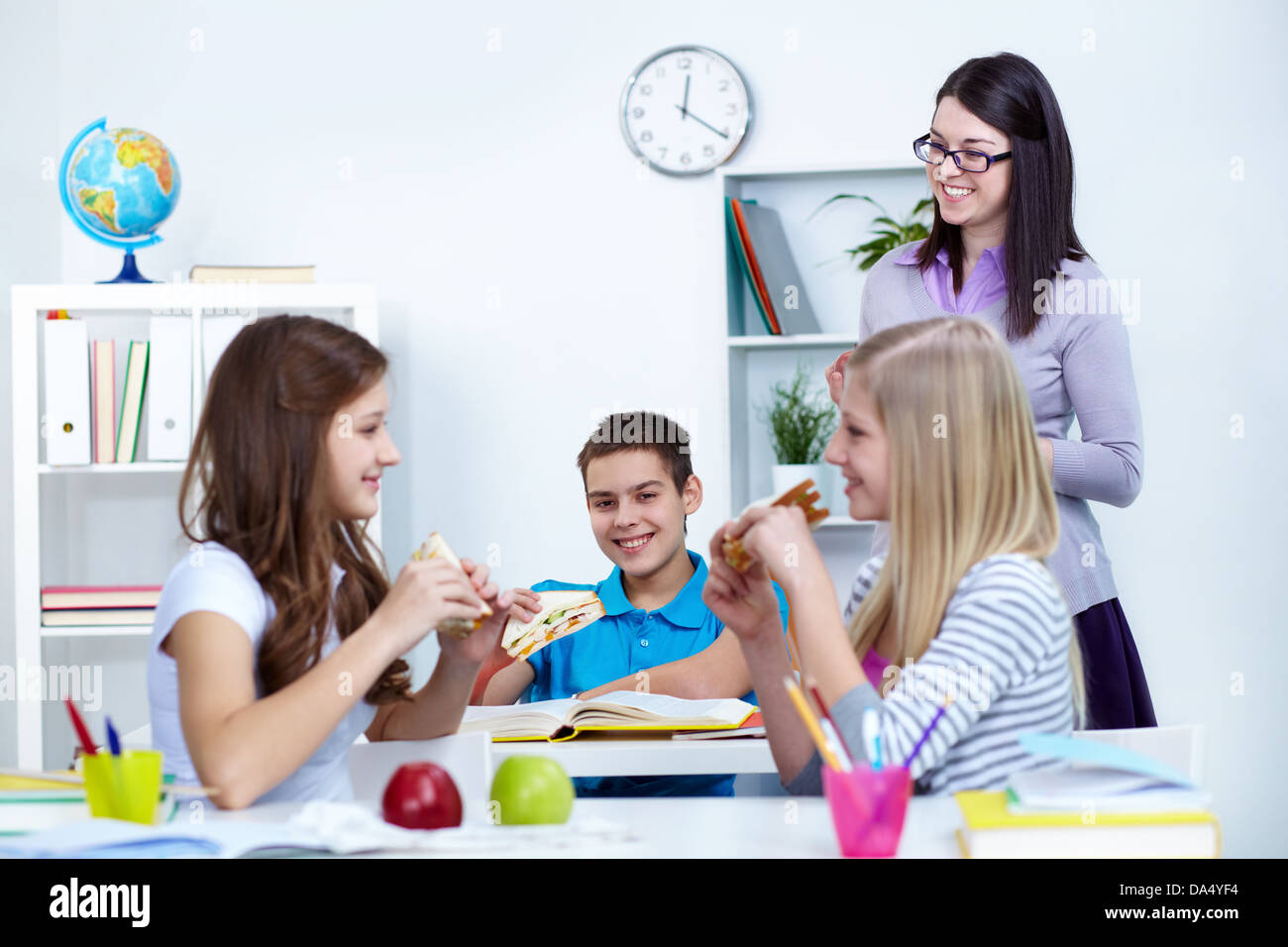 Hungry students eating sandwiches during break in college with their ...