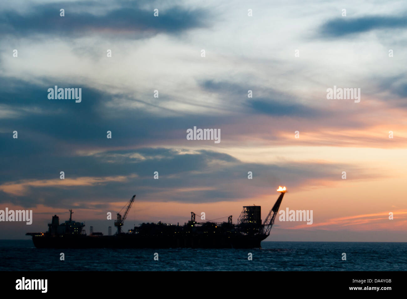silhouette of an offshore FPSO oil rig at sunset/sunrise dusk time ...